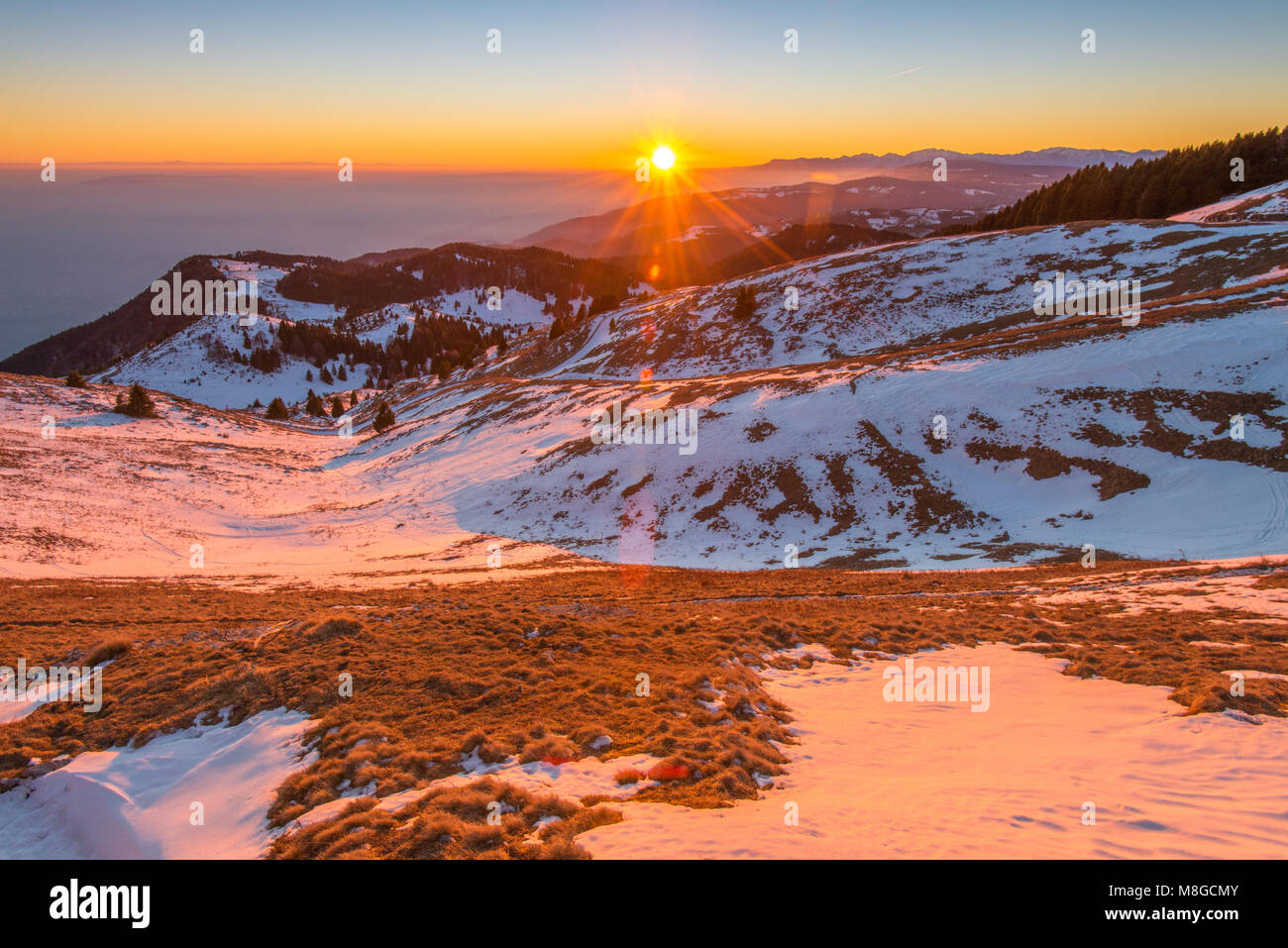Serene sunset with amazing alpenglow, sun turning the mountains golden ...
