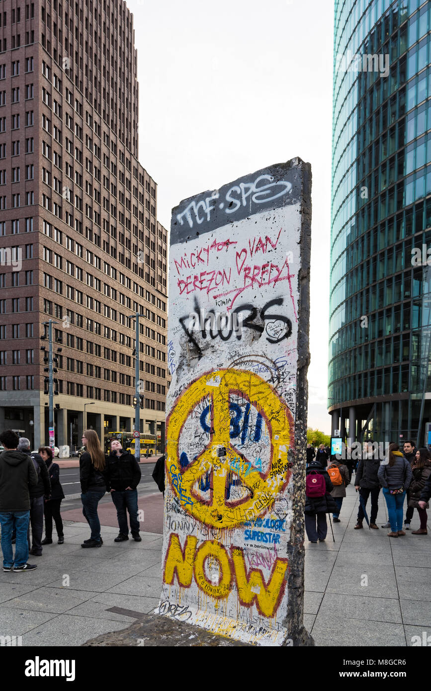 Modern buildings and a full of inscriptions piece of the Berlin Wall at ...