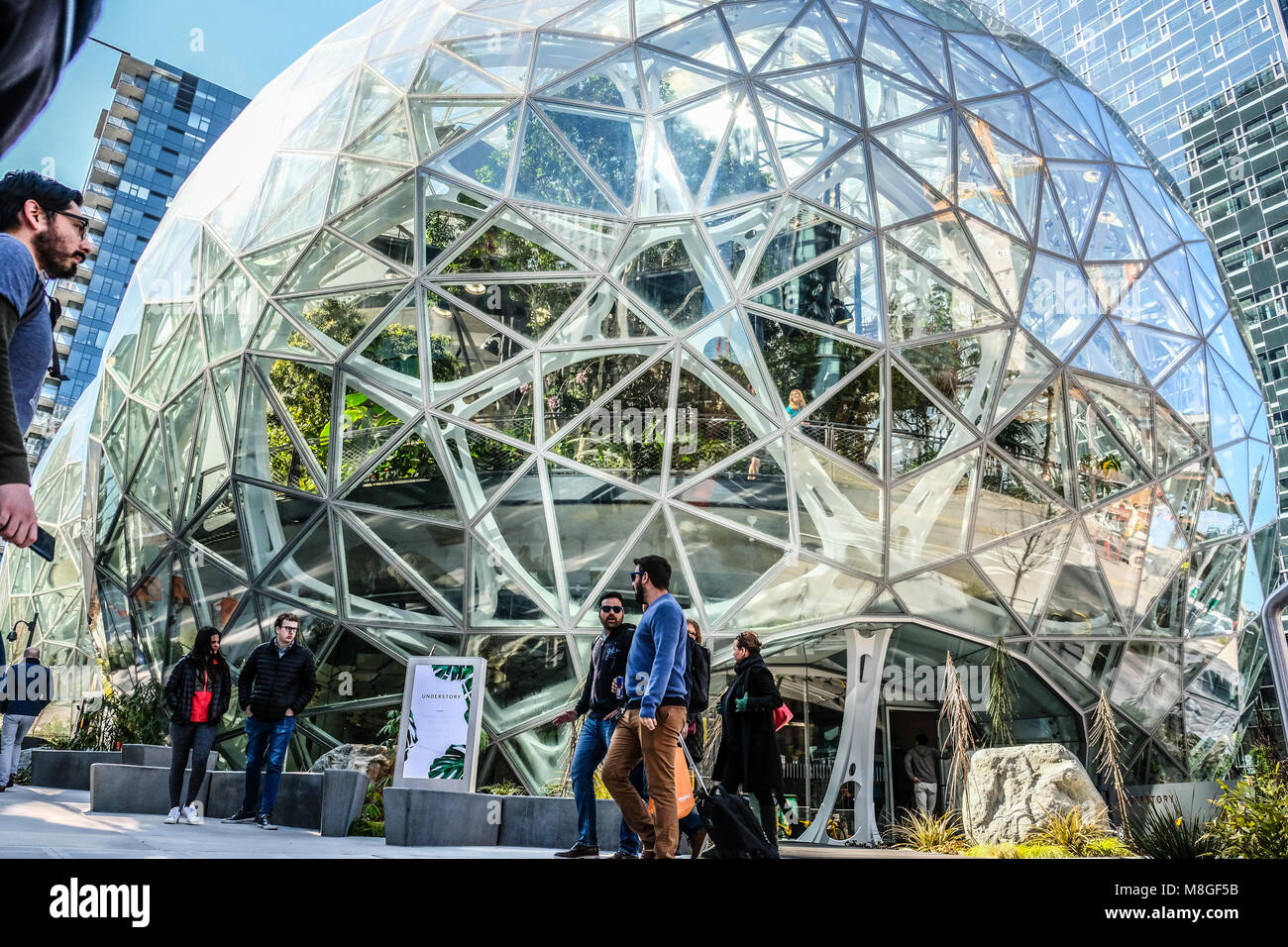 People walking by the glass dome Spheres at Amazon headquarter in ...