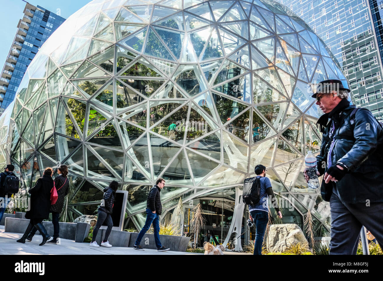 People walking by the glass dome Spheres at Amazon headquarter in ...