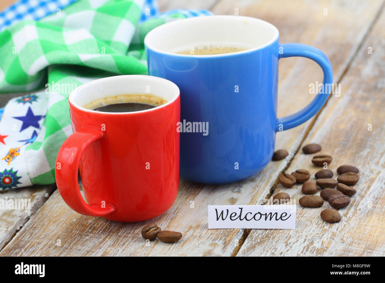 Welcome card with two colorful mugs of coffee on rustic wooden surface ...