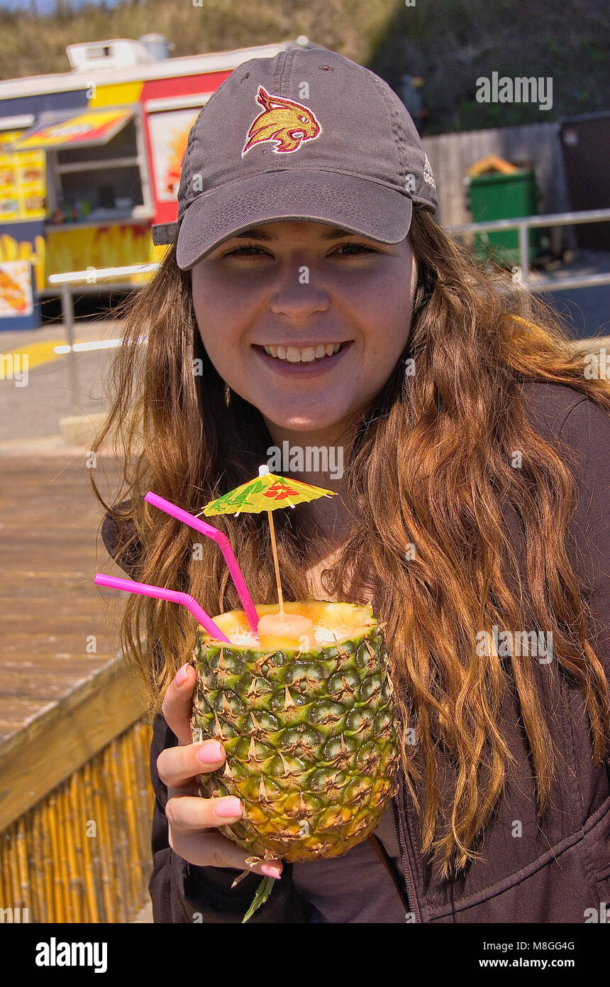 A young woman drinking a pineapple fruity drink from shell Stock Photo ...