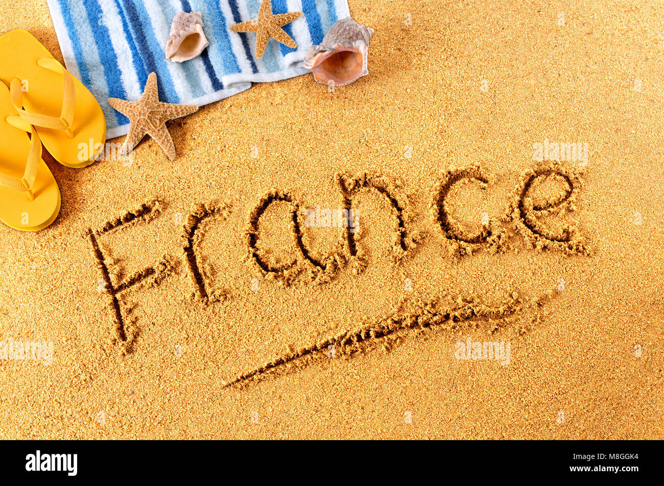 The word France written on a sandy beach, with scuba mask, starfish and ...