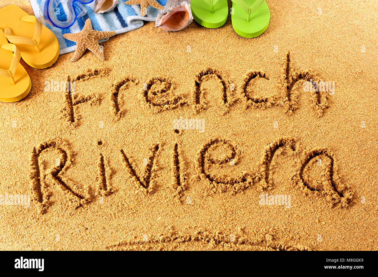 The words French Riviera written on a sandy beach, with scuba mask ...