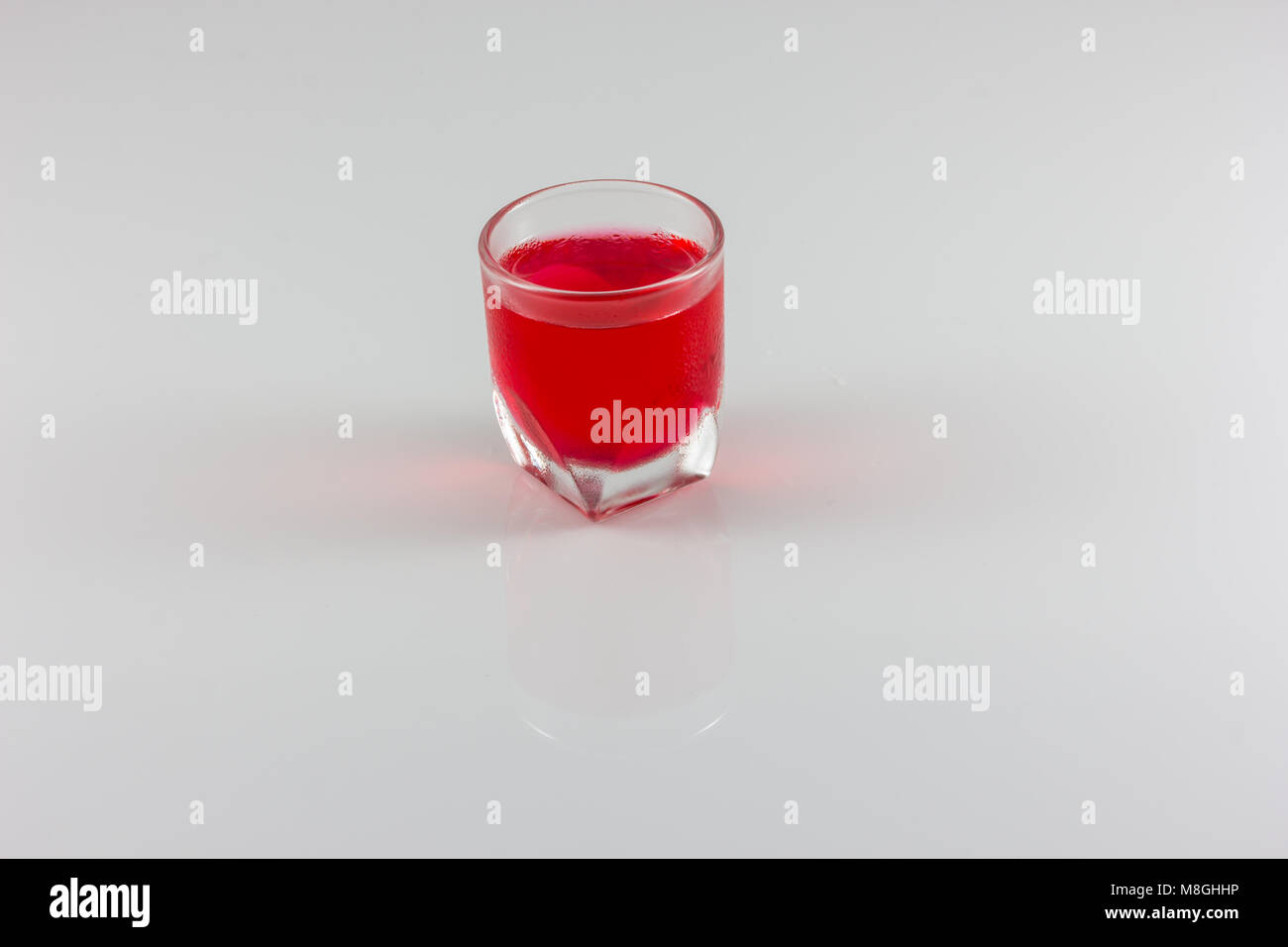 a glass of red water isolate in white background Stock Photo - Alamy