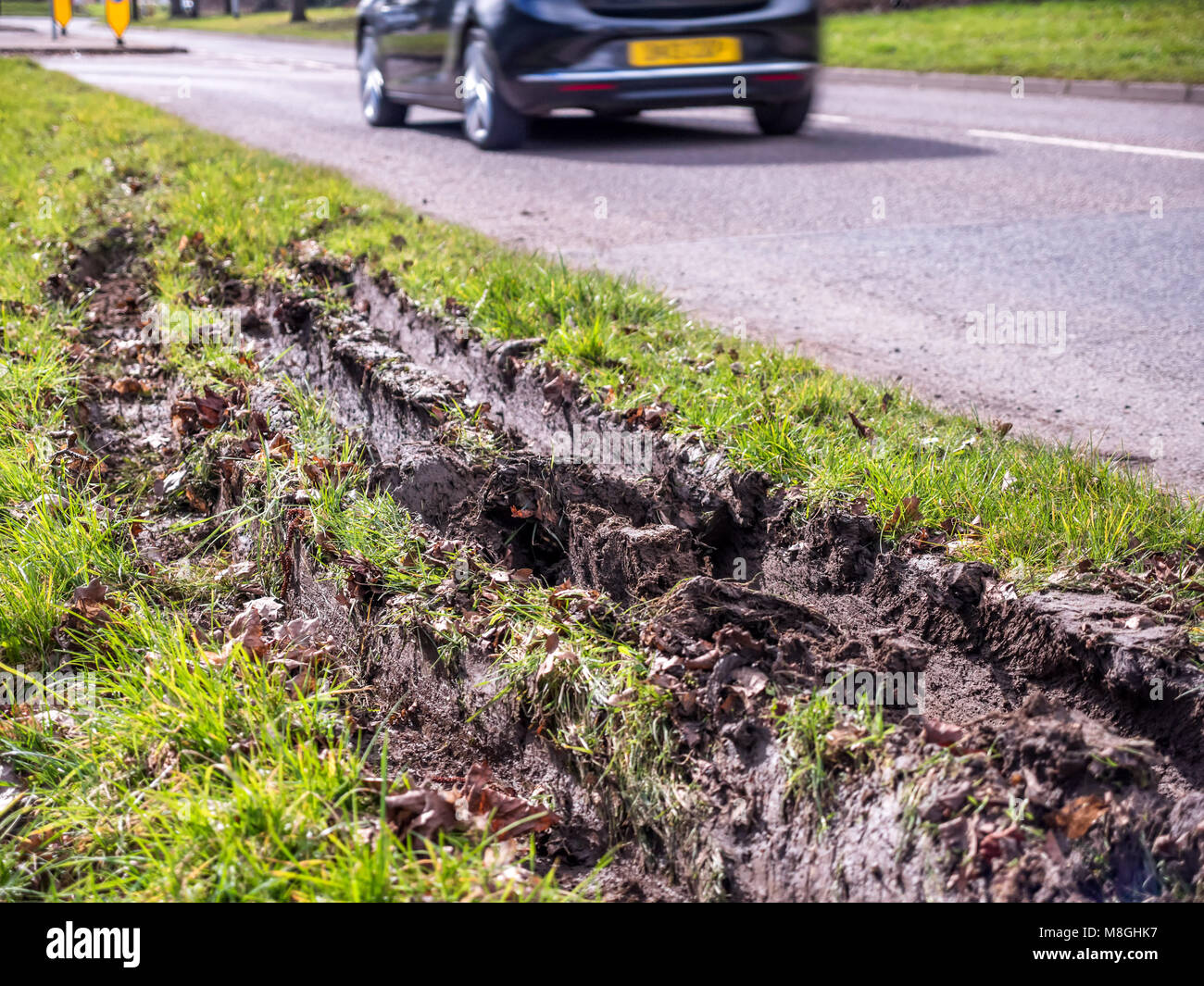 Closeup view of car wheel tracks traces in mud next to British road ...