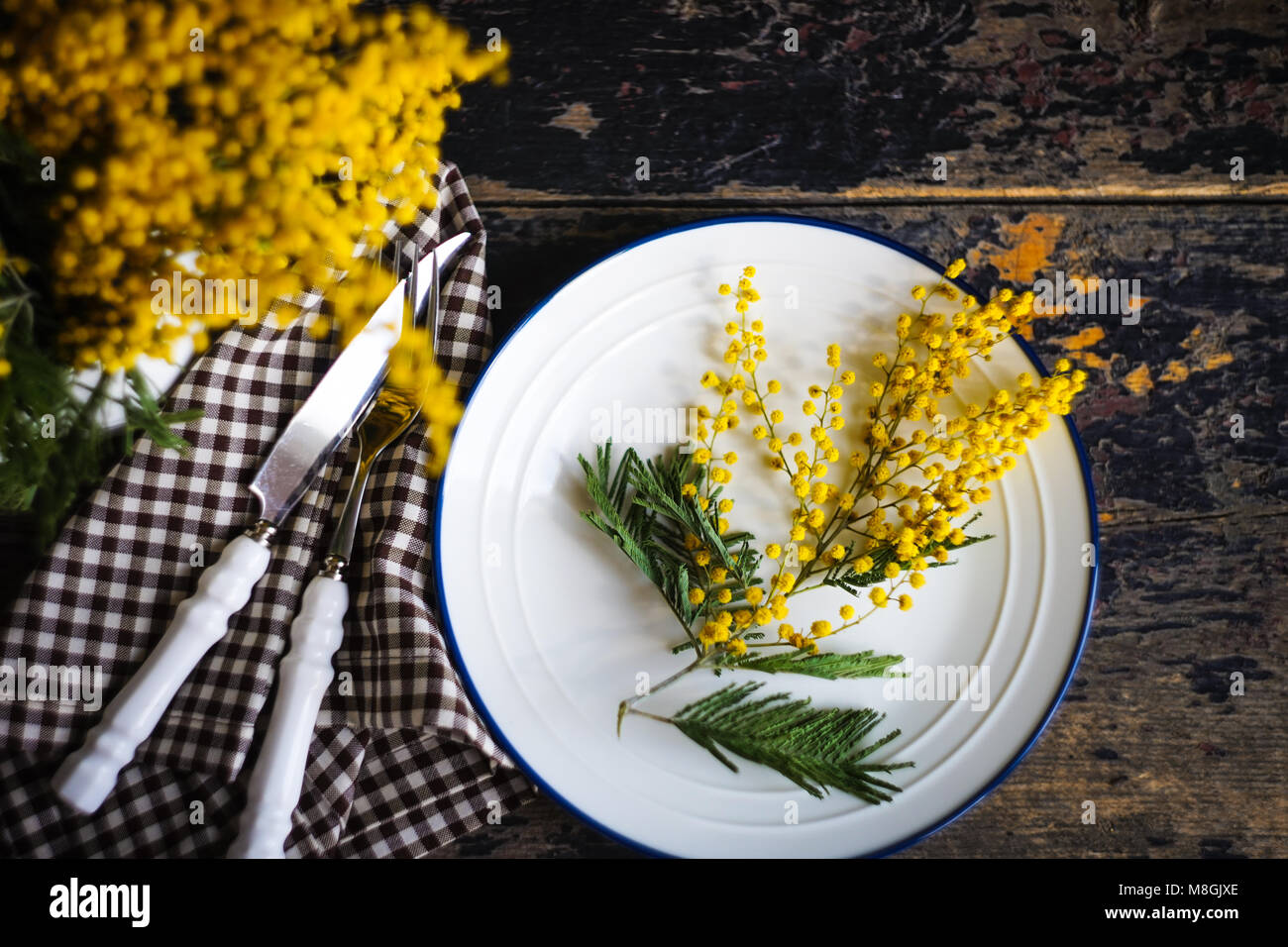 Spring table setting with bright yellow mimosa flowers Stock Photo - Alamy