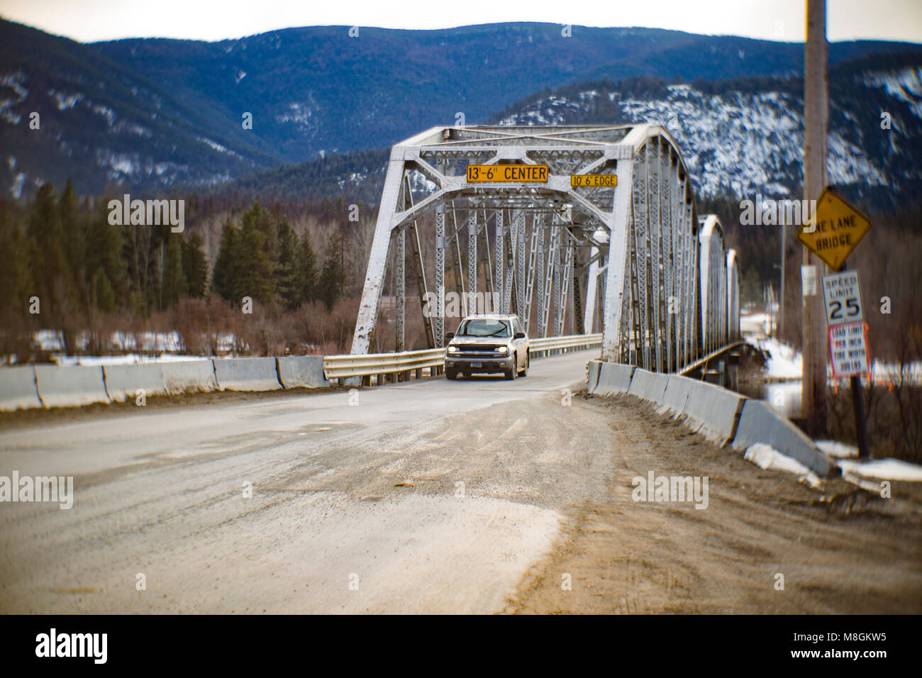 A car crossing the single lane steel bridge over the Clark Fork River ...