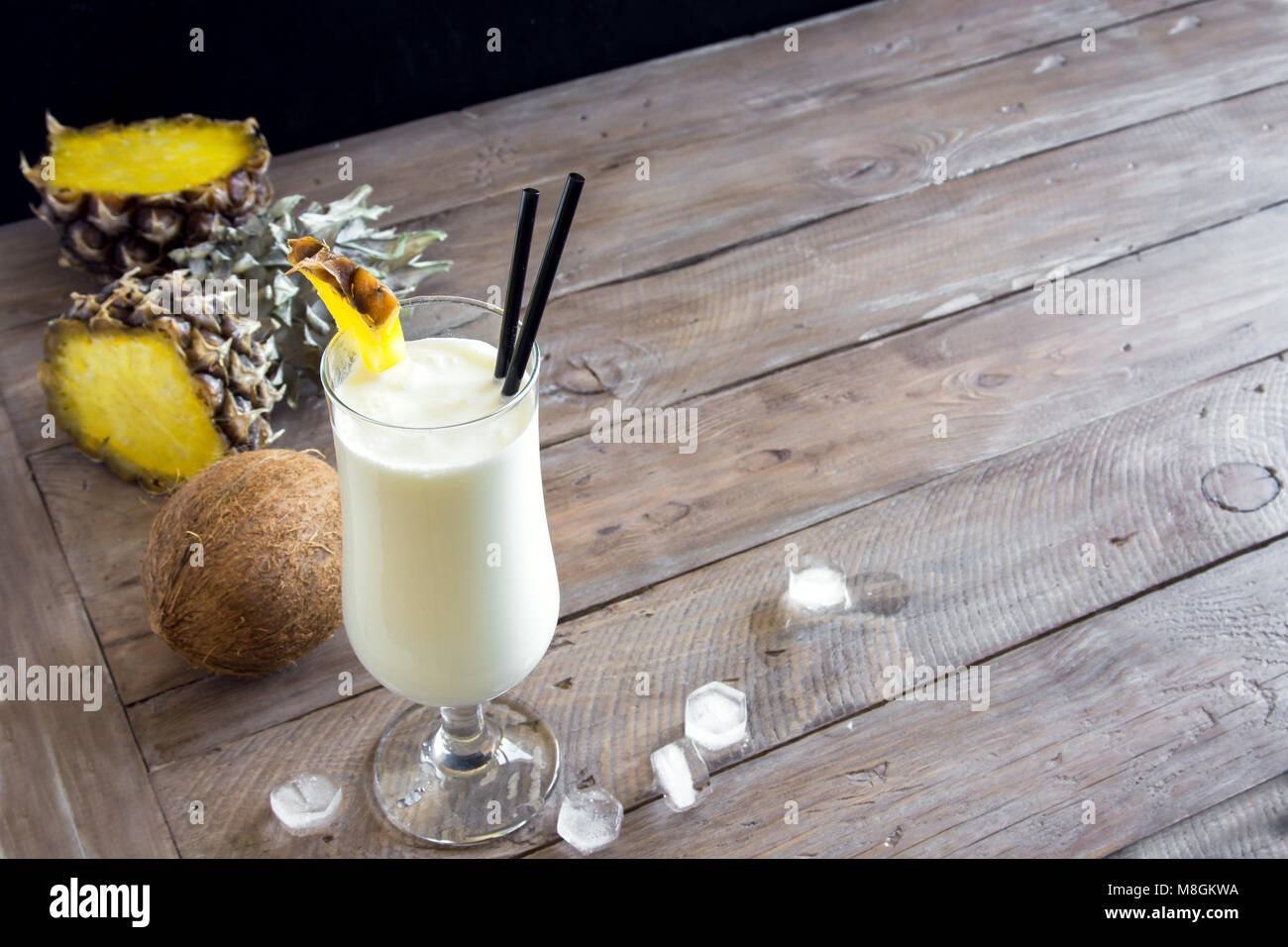 Pina Colada Cocktail with pineapple and coconut over wooden background ...