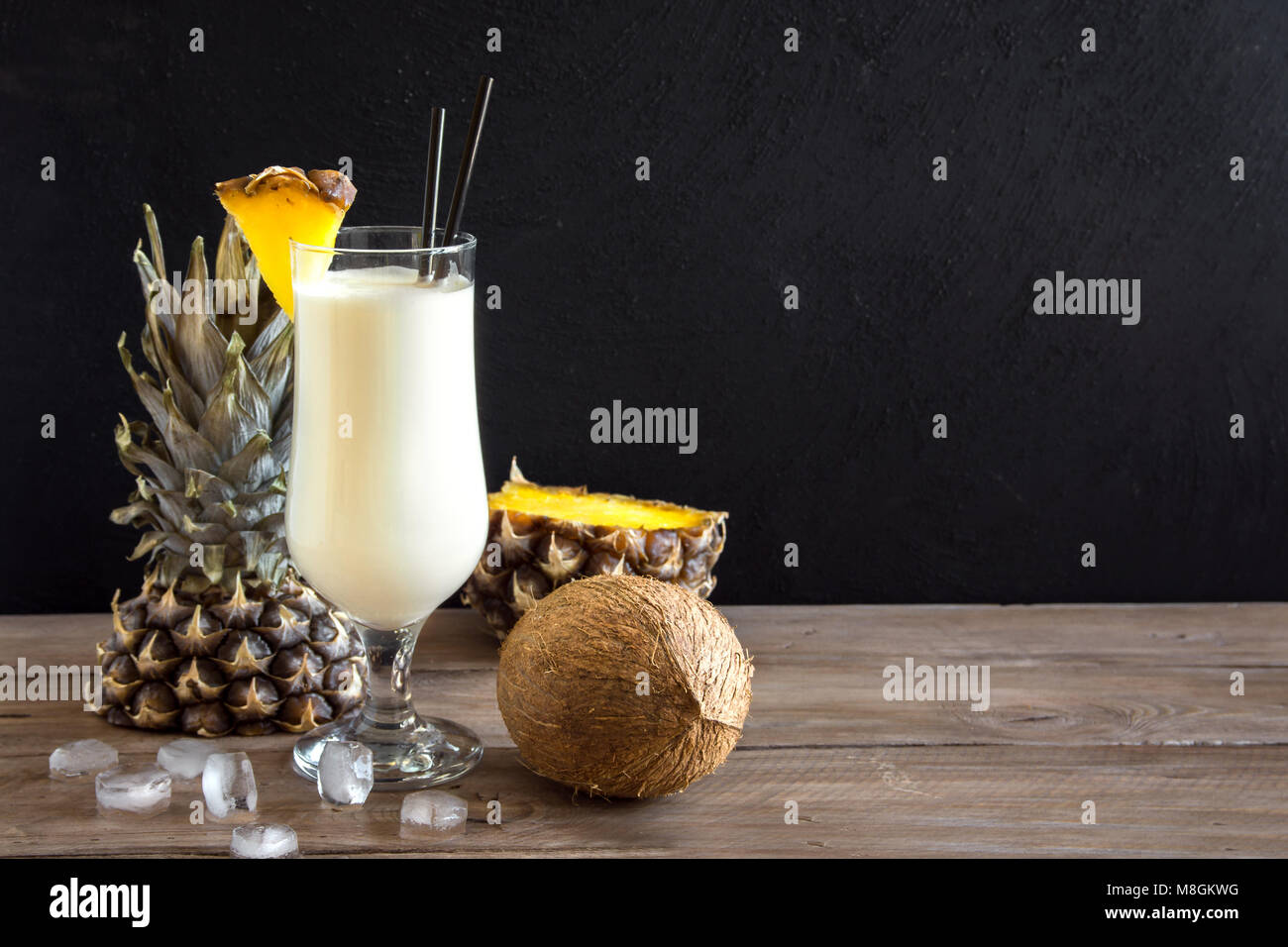 Pina Colada Cocktail with pineapple and coconut over wooden background ...