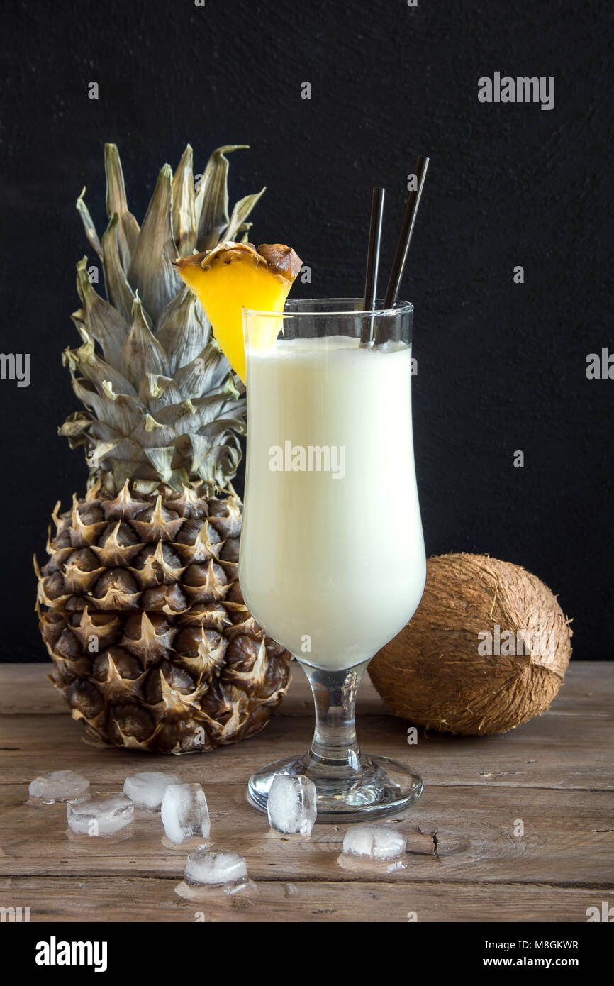 Pina Colada Cocktail with pineapple and coconut over wooden background ...