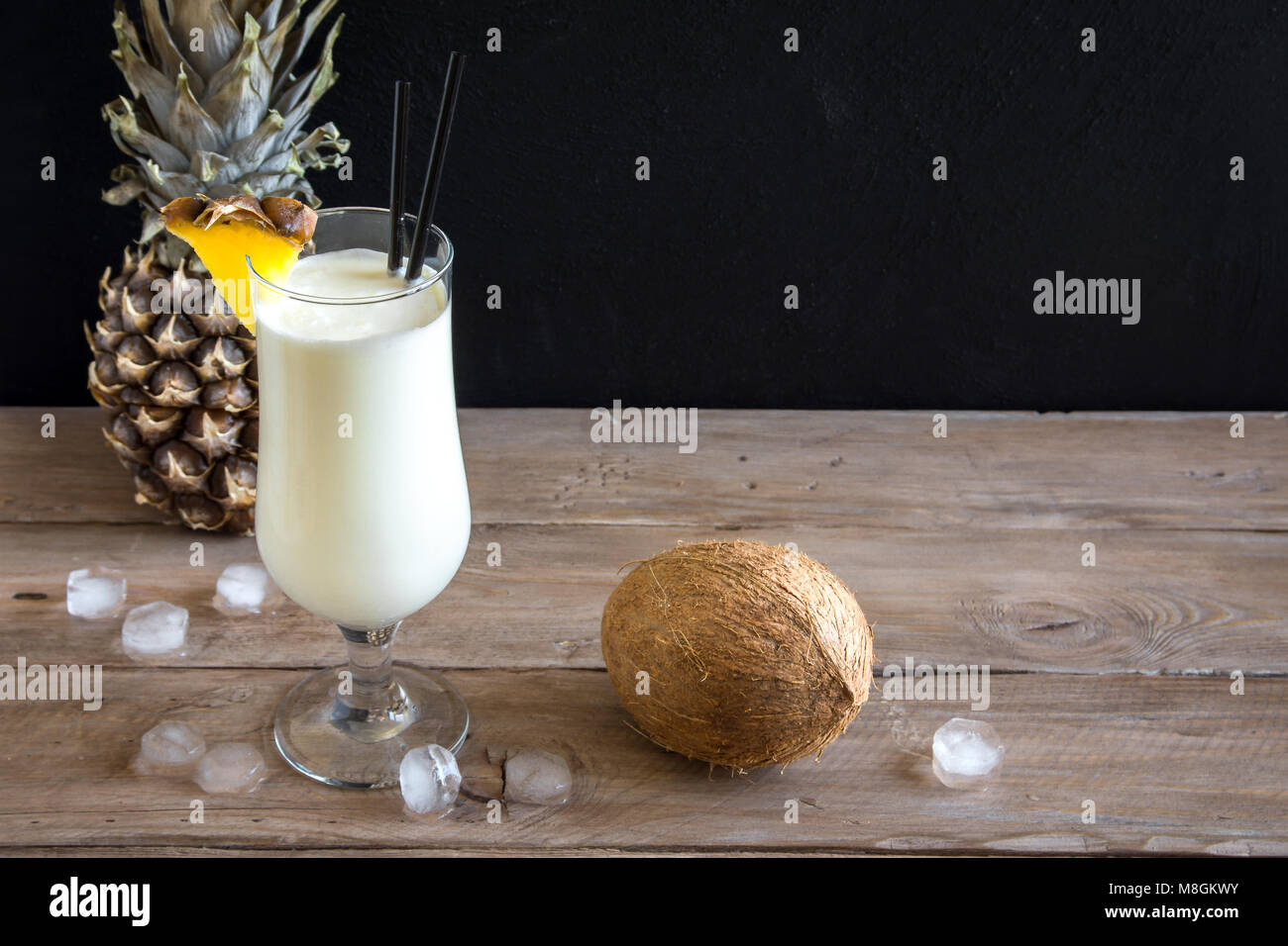 Pina Colada Cocktail with pineapple and coconut over wooden background ...