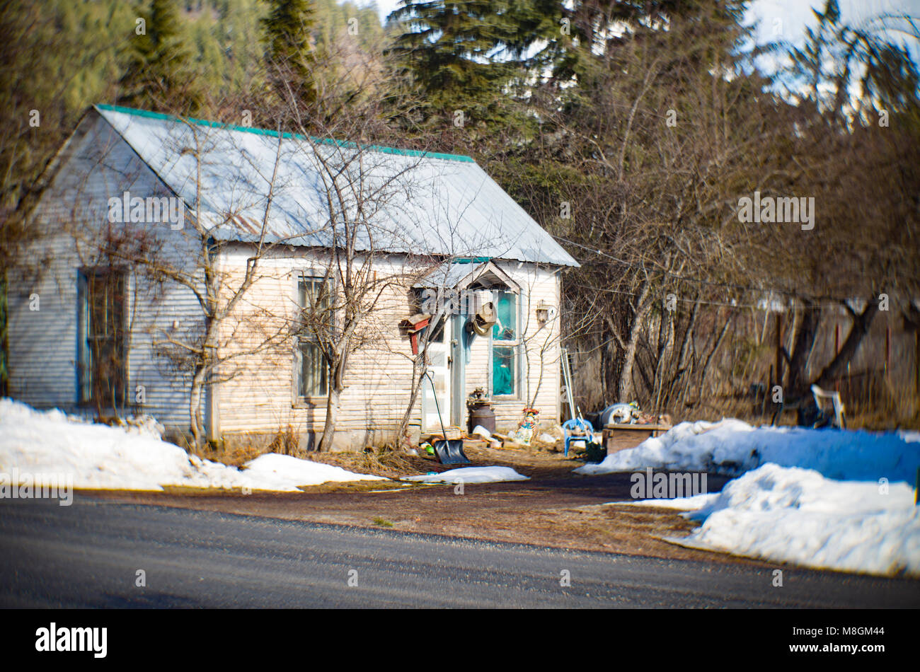 A small white wood frame house, with a messy yard, in the town of Clark ...