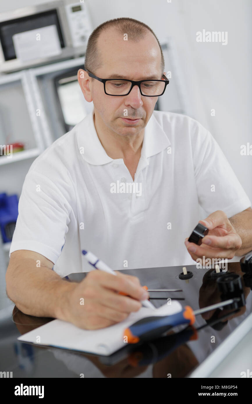 appliance technician writing his notes Stock Photo - Alamy