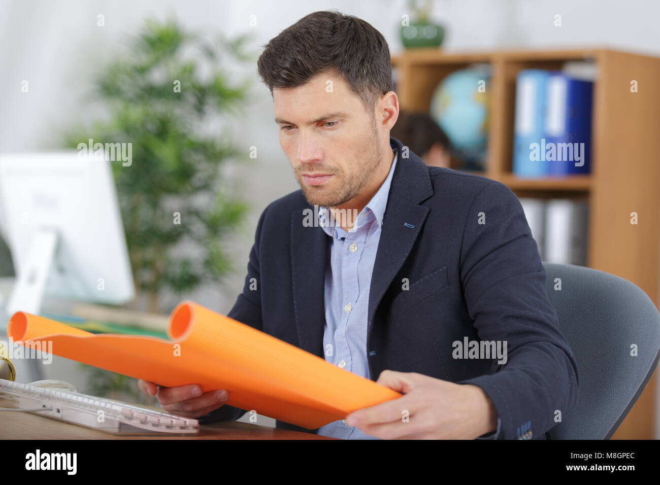 businessman opening roll of colored paper Stock Photo - Alamy