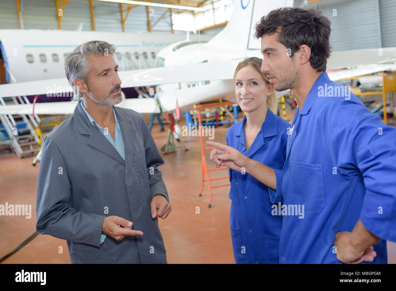 young engineers with wrench fixing part of jetliner Stock Photo - Alamy