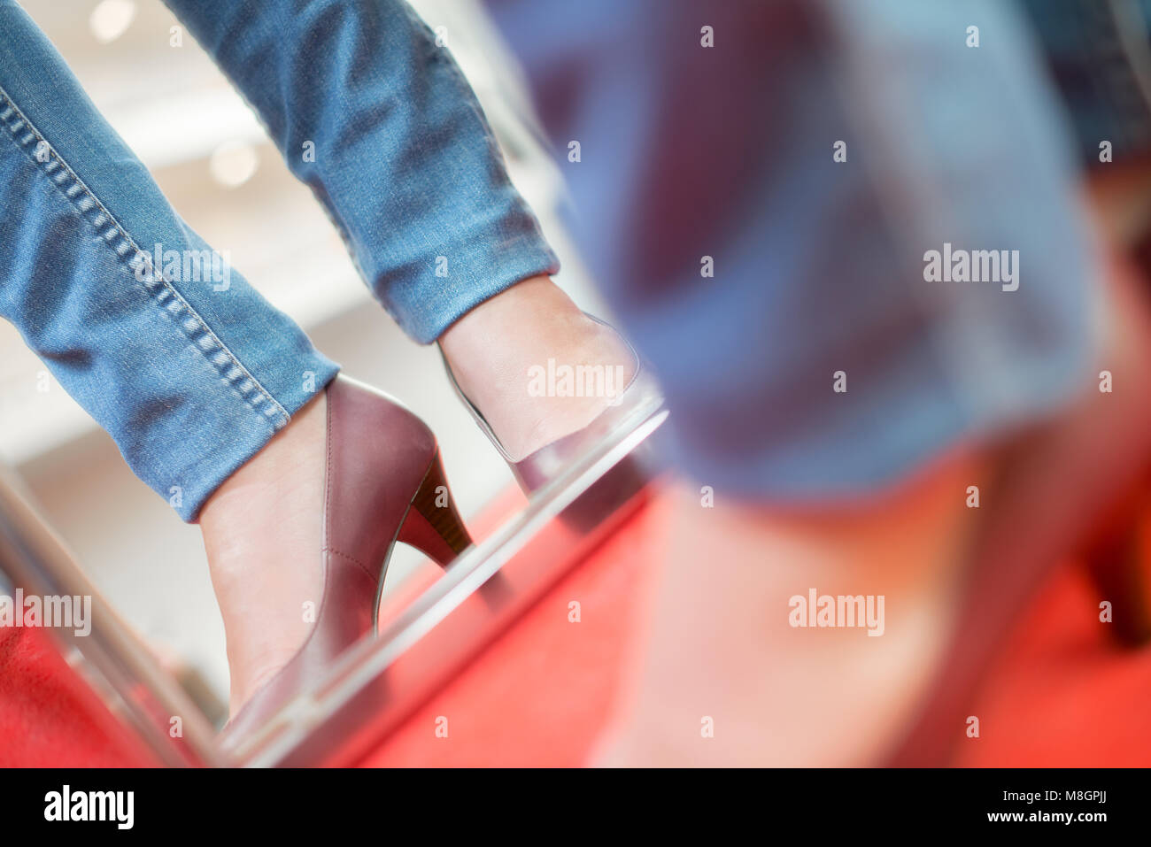 Lady looking at shoes in mirror Stock Photo - Alamy