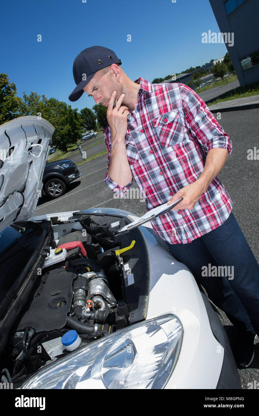mechanic inspecting the cars engine Stock Photo - Alamy