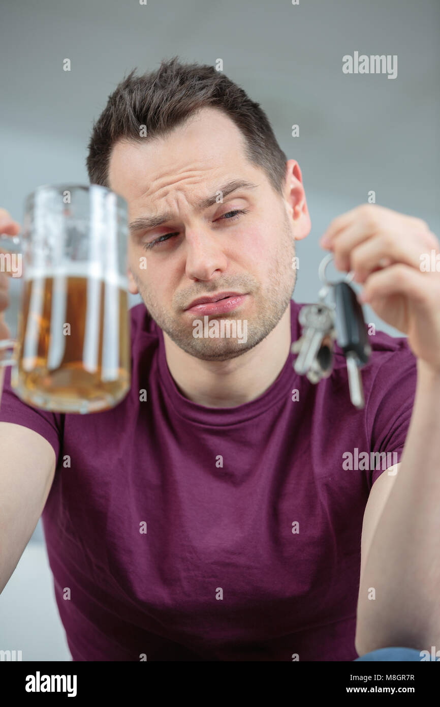 young drunk man with car key and bottle of beer Stock Photo - Alamy