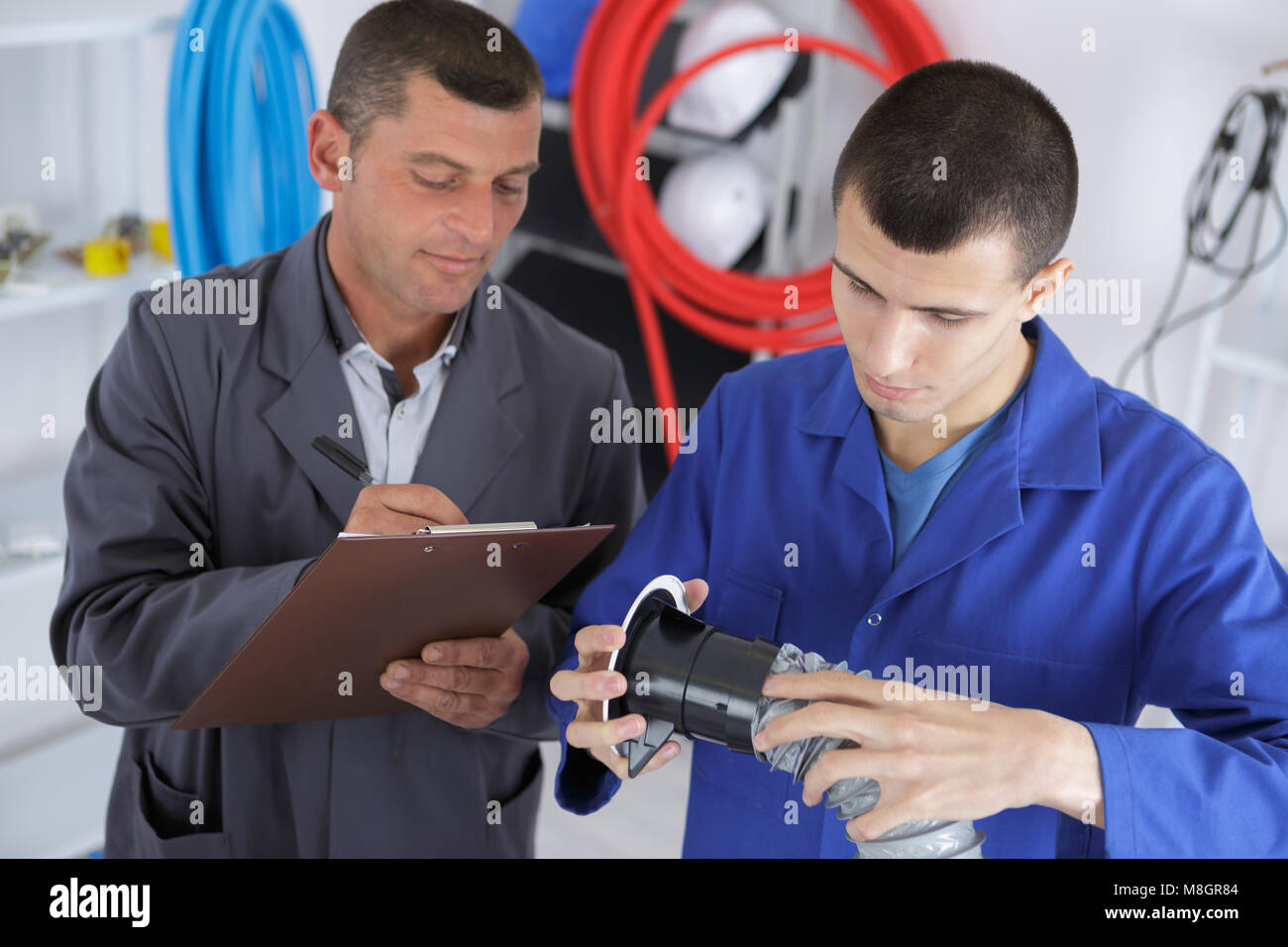 professional trainer teaching student how to fix car engine Stock Photo ...