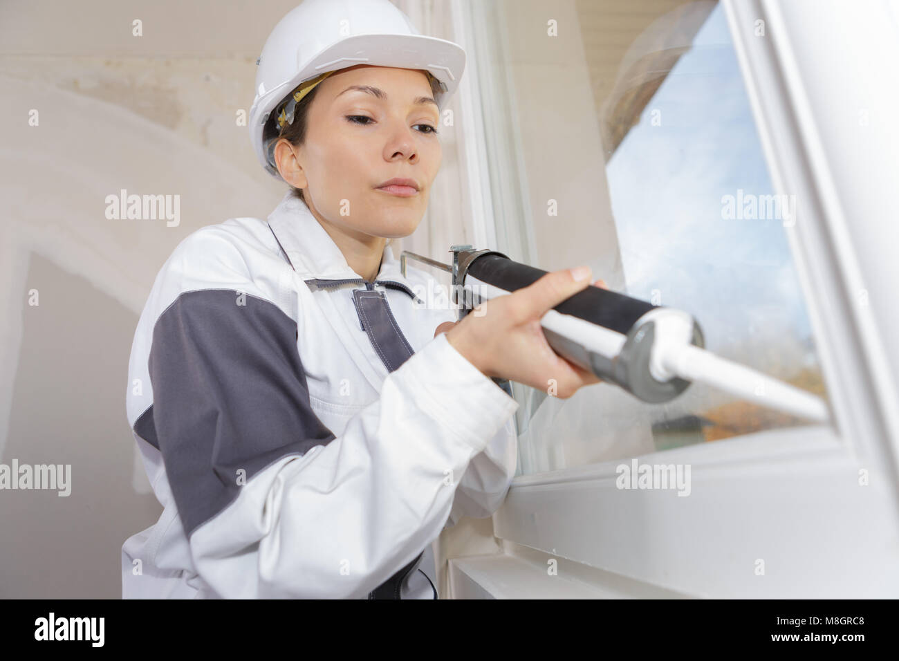 female construction worker installing window in house Stock Photo - Alamy