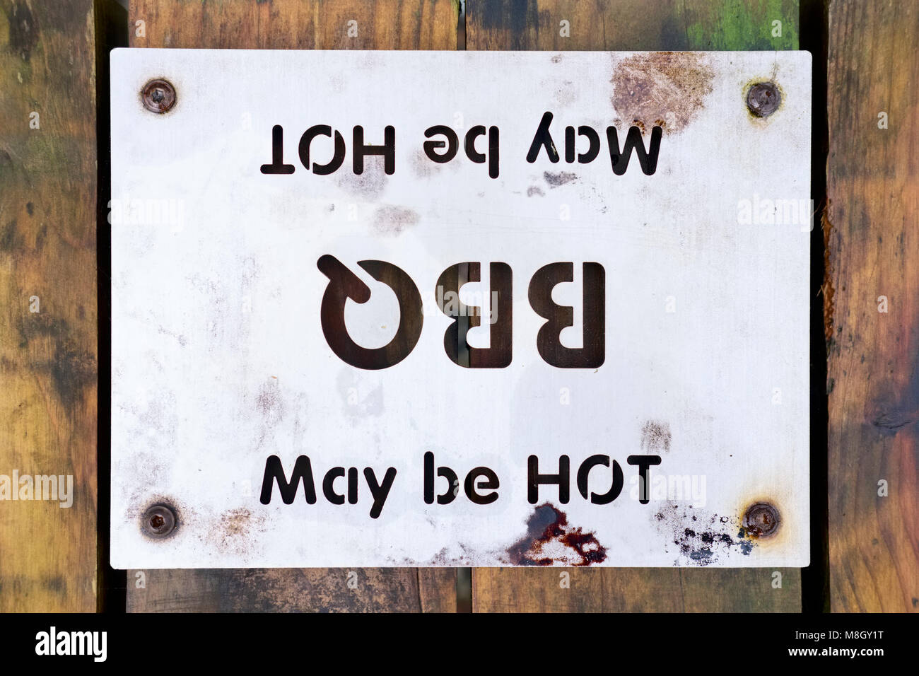 BBQ barbecue may be hot sign silver metal on picnic table bench Stock ...