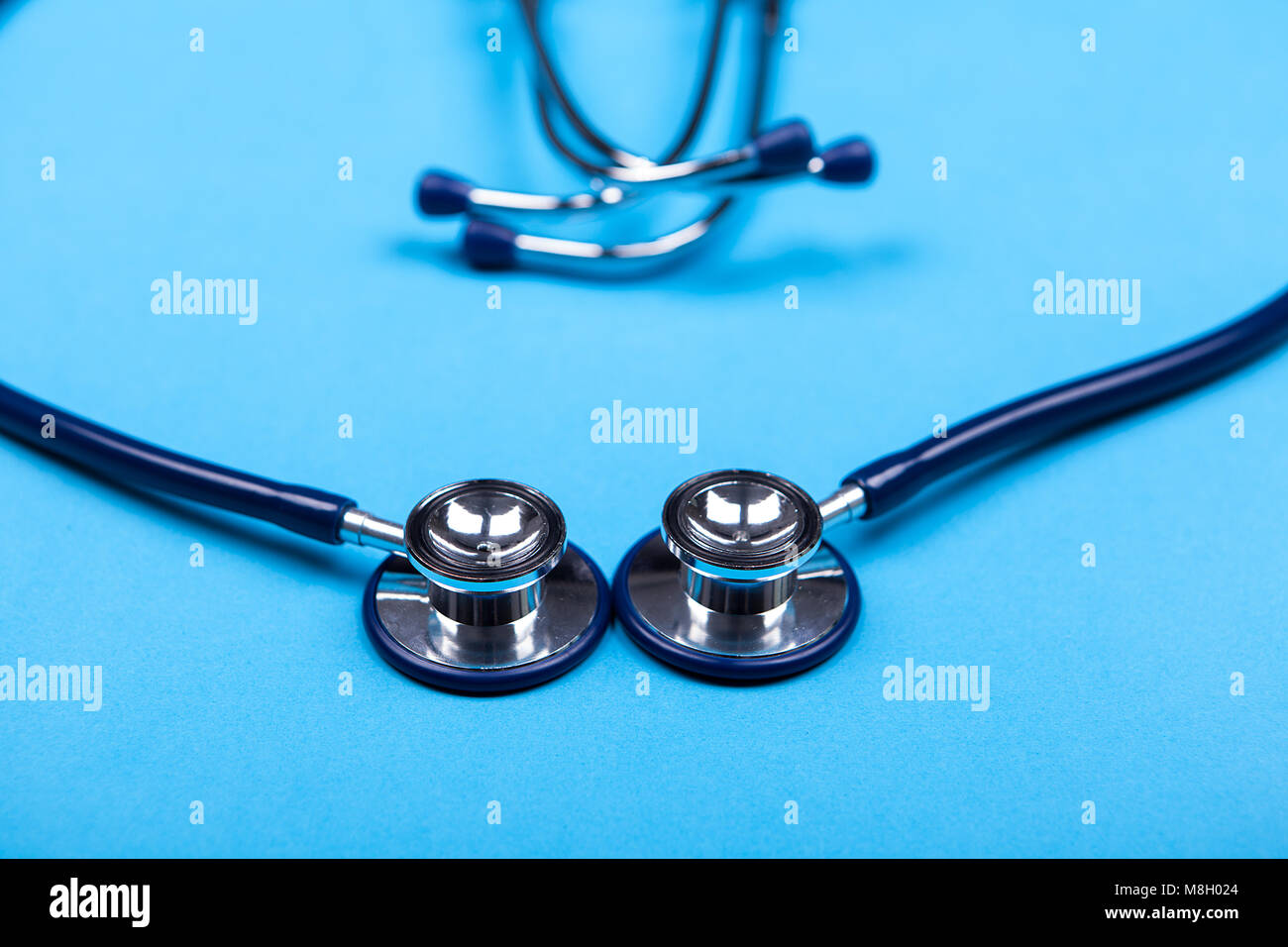 Two professional stethoscopes on blue background Stock Photo - Alamy