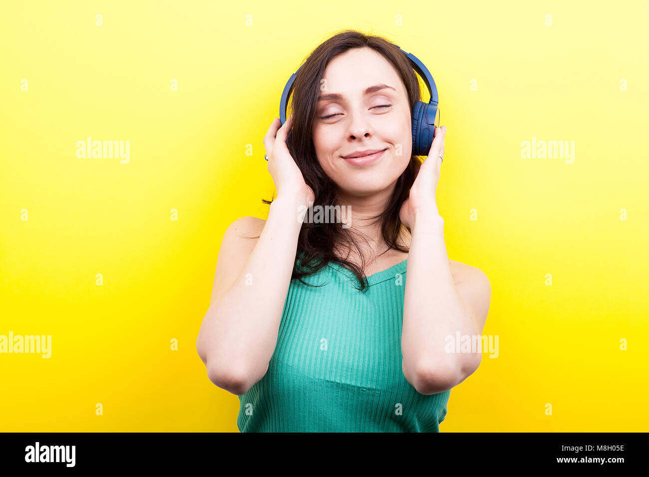 Young woman with her eyes closed listening to music through head Stock ...