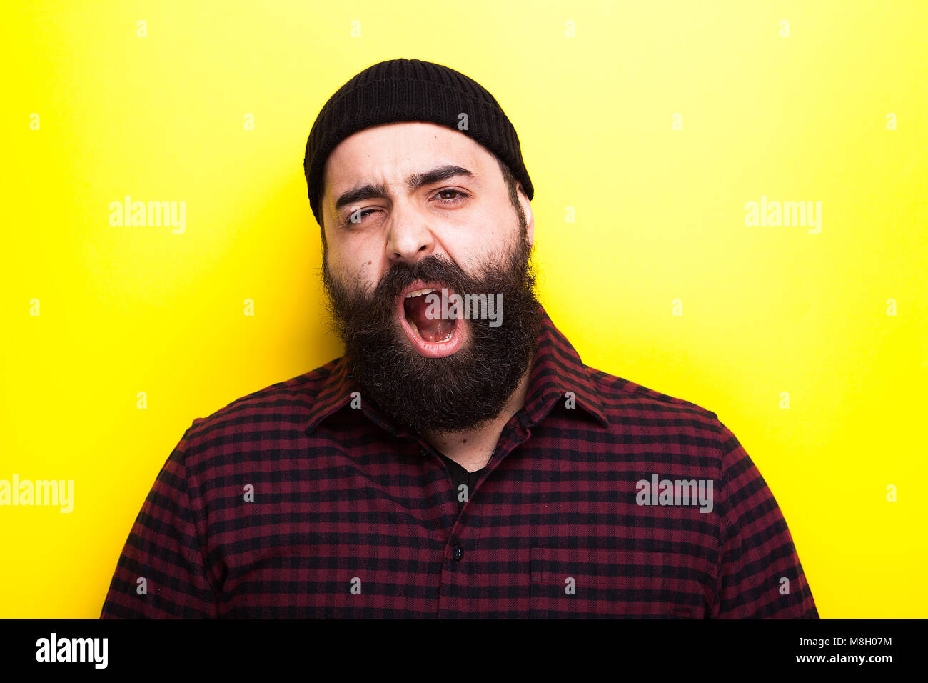 Yawning hipster with long beard Stock Photo - Alamy