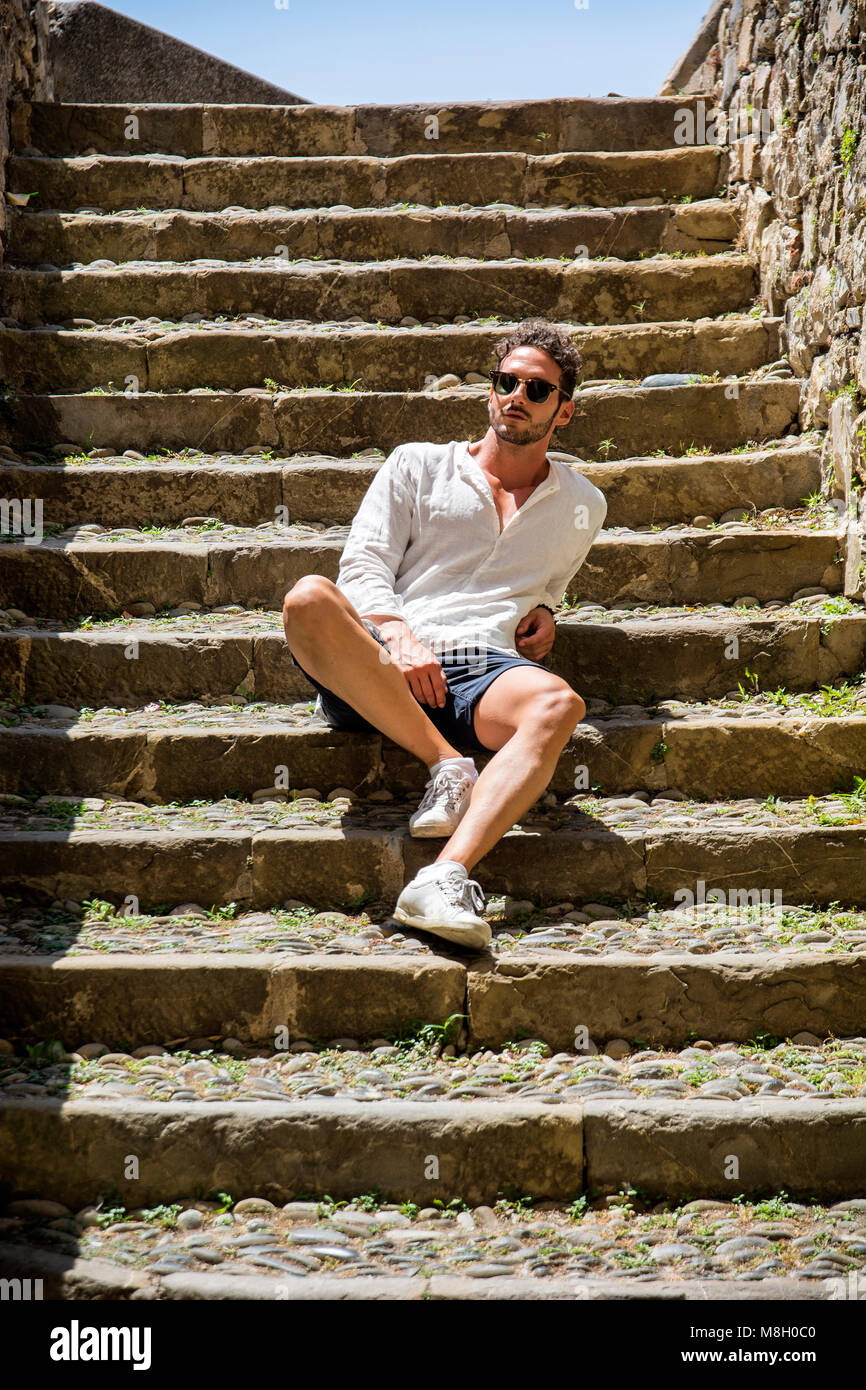 Relaxing stylish man sitting on stairs Stock Photo - Alamy