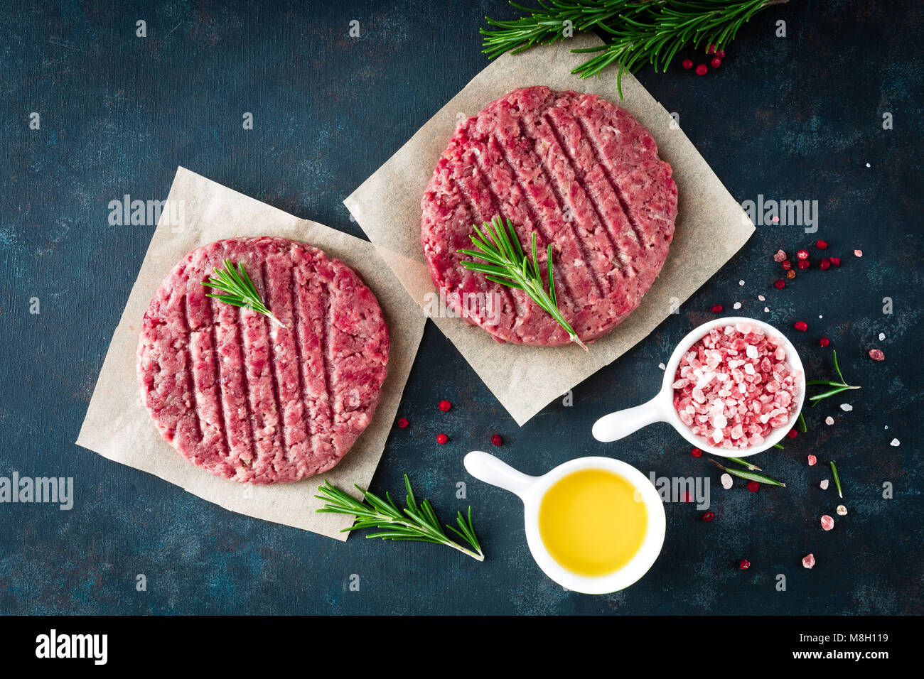 Fresh minced beef meat burgers with spices on dark background. Raw ...