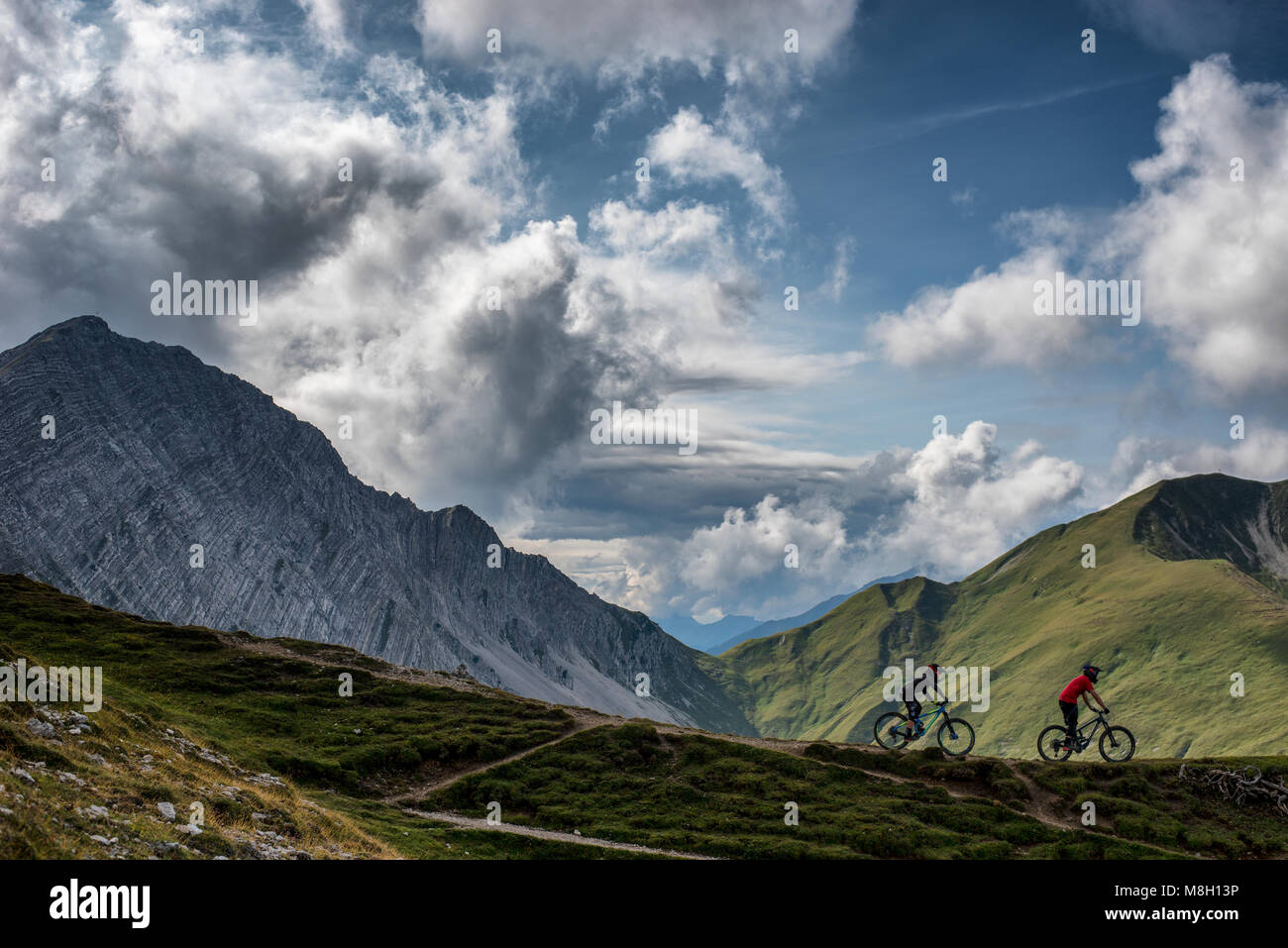 Two mountain bikers ride along a ridge in the Austrian alpine resort of ...