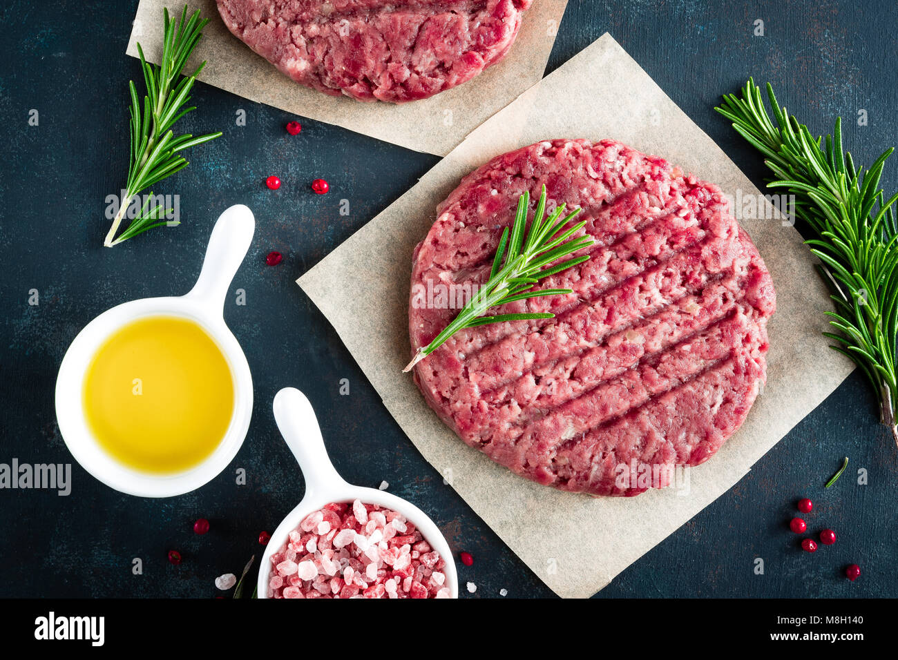 Fresh minced beef meat burgers with spices on dark background. Raw ...