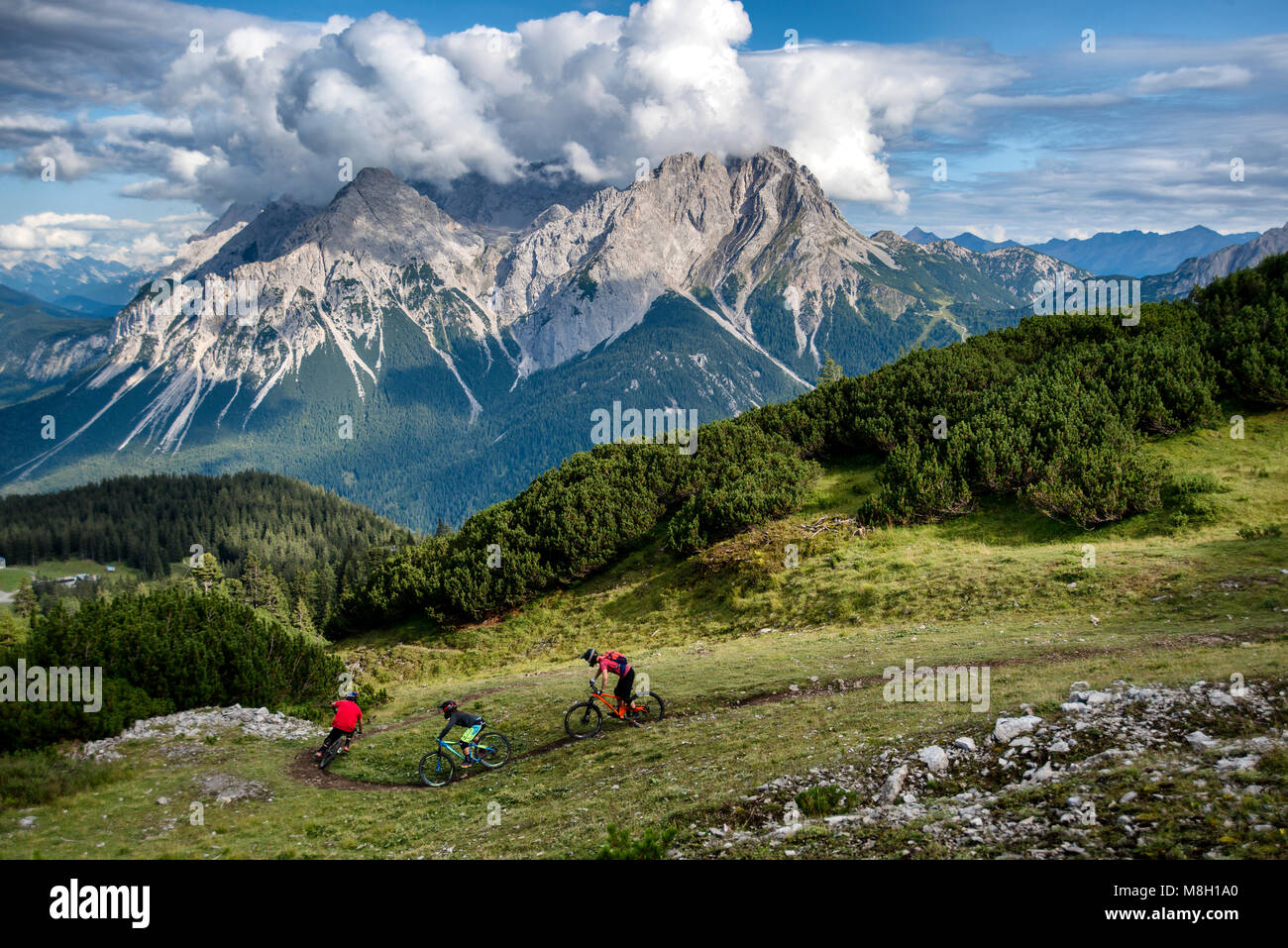 Three mountain bikers ride a trail in the Austrian alpine resort of ...