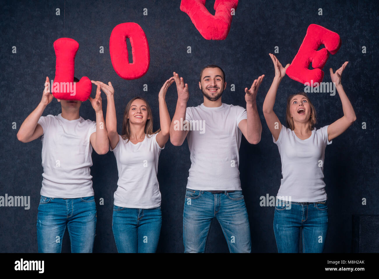 Courting couples throw up in the air the letters of the word Love Stock ...