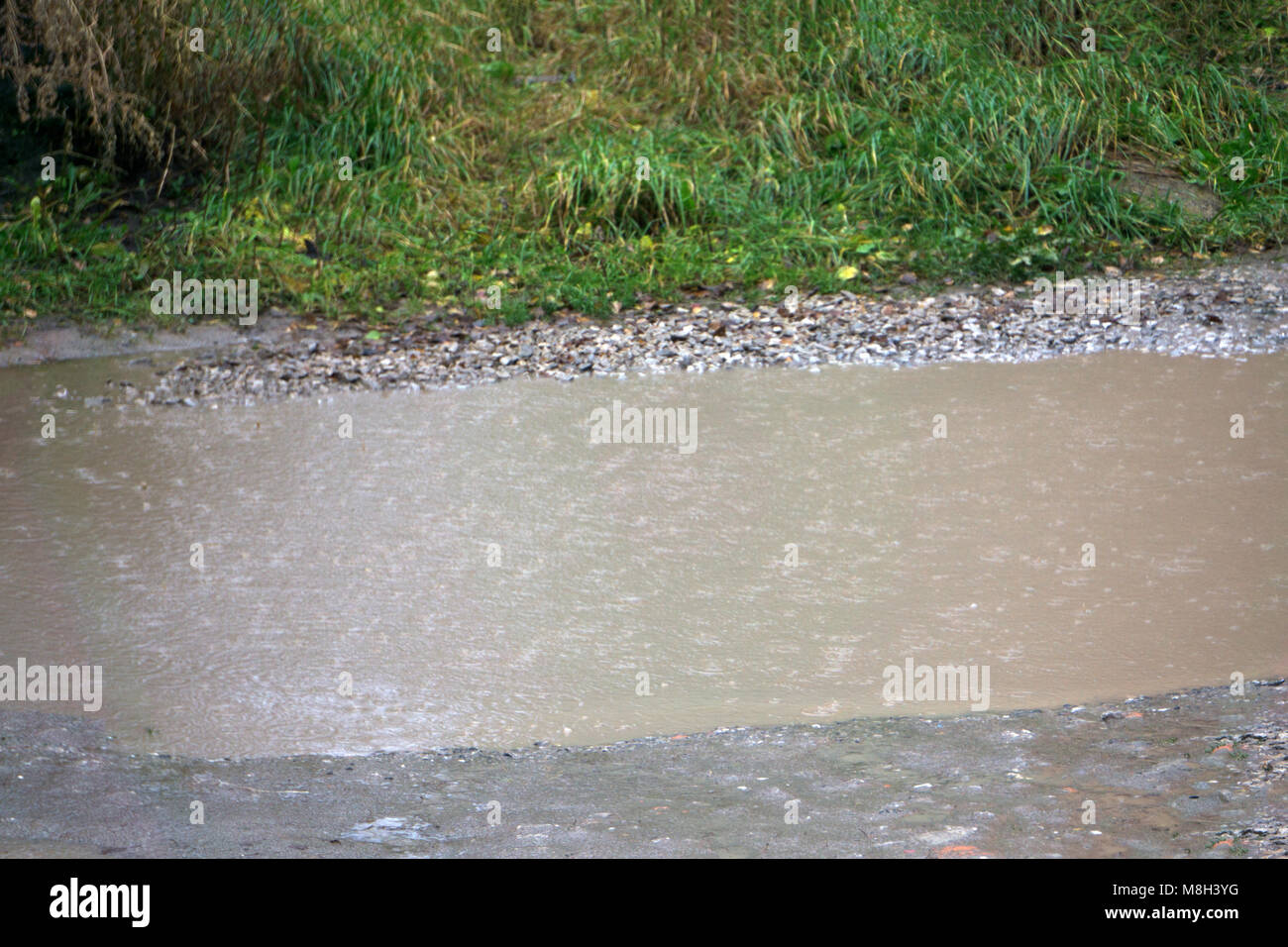 Close up of large puddle causes from heavy rain resulting in flooding ...