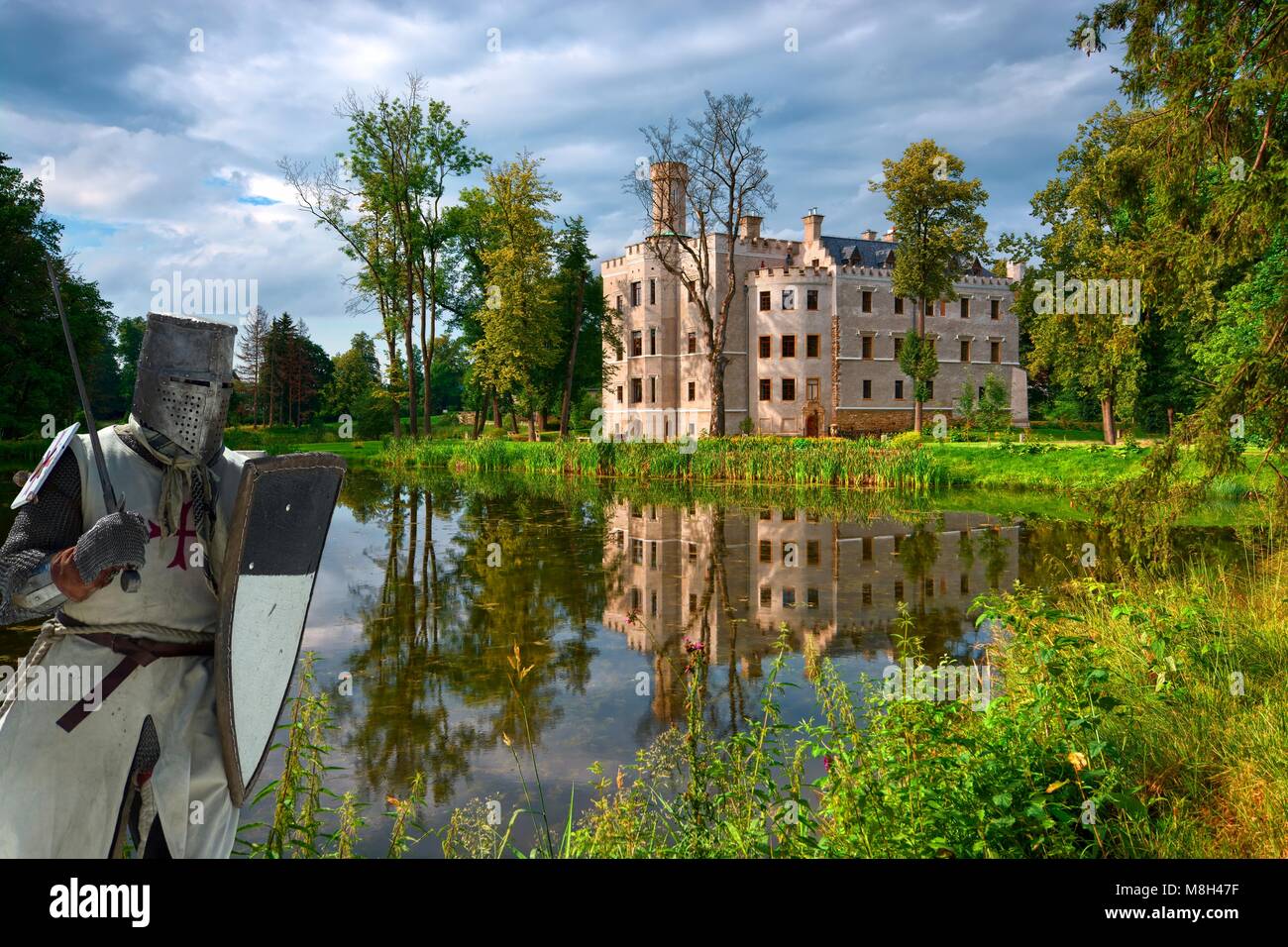 Templar knight with neo-Gothic style castle surrounded by a moat in ...