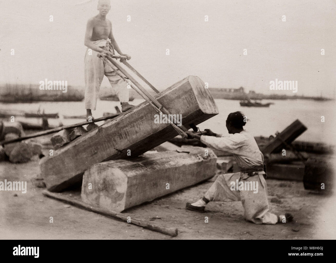 c.1900 China - carpenters sawing a log Stock Photo - Alamy