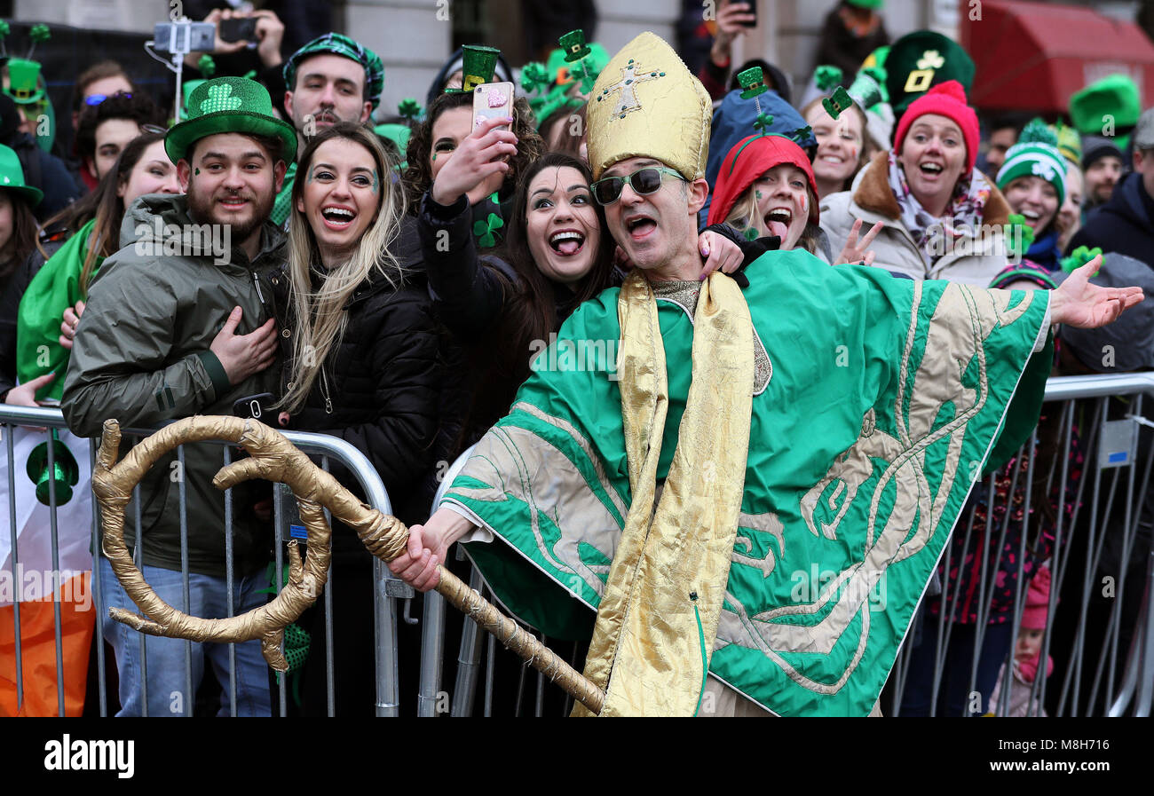 A man dressed as St. Patrick poses for a selfie as the St Patrick's day ...
