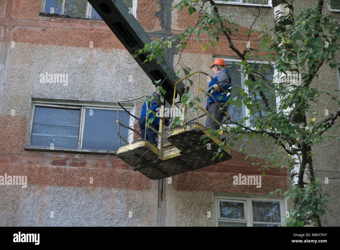 The tower vehicle in repair of a facade of an old inhabited apartment ...