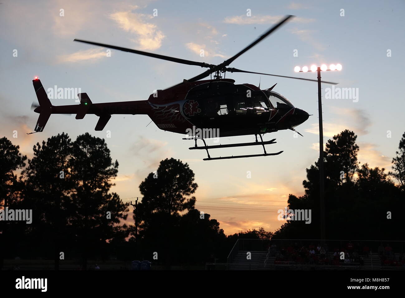 Helicopter delivers the game ball at a Friday night football game Stock ...