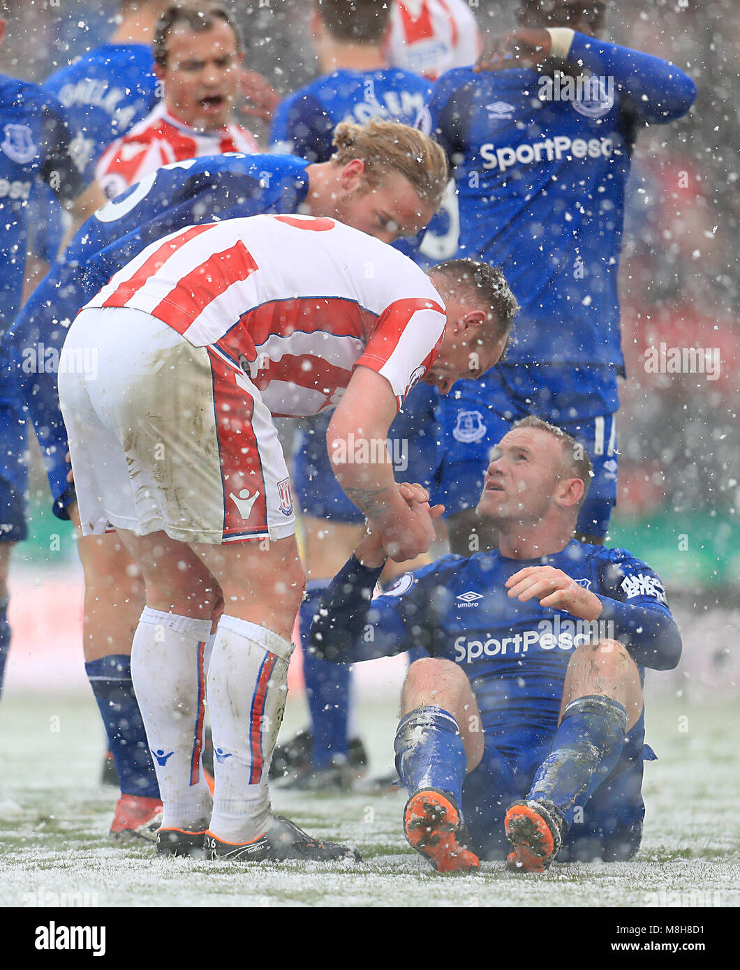 Stoke City's Charlie Adam helps up Everton's Wayne Rooney after a foul ...