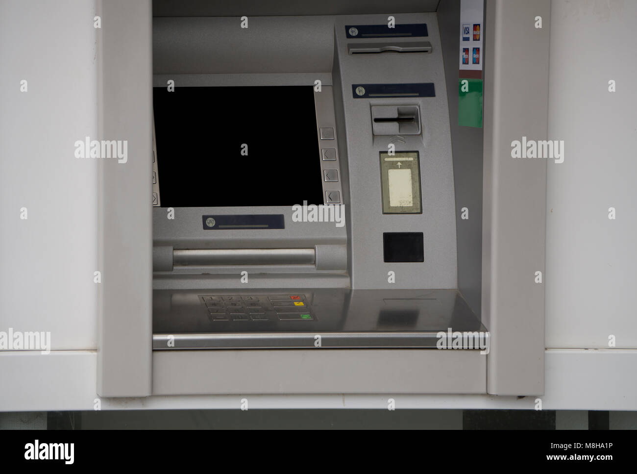 A gray ATM in the wall. Black frame Stock Photo - Alamy