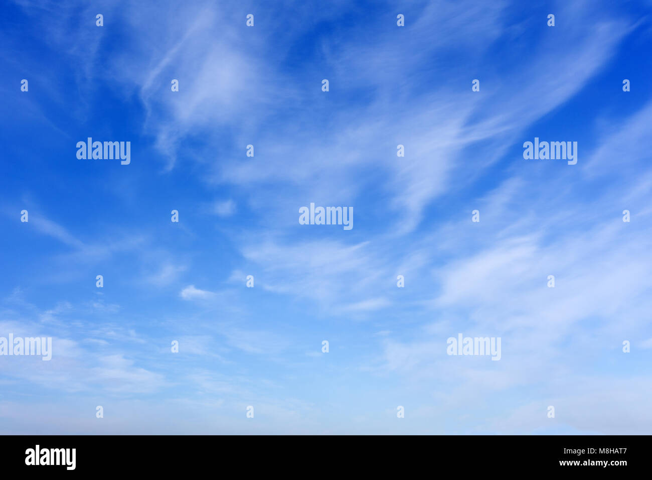 Pale blue sky saturated color. White scattered clouds Stock Photo - Alamy