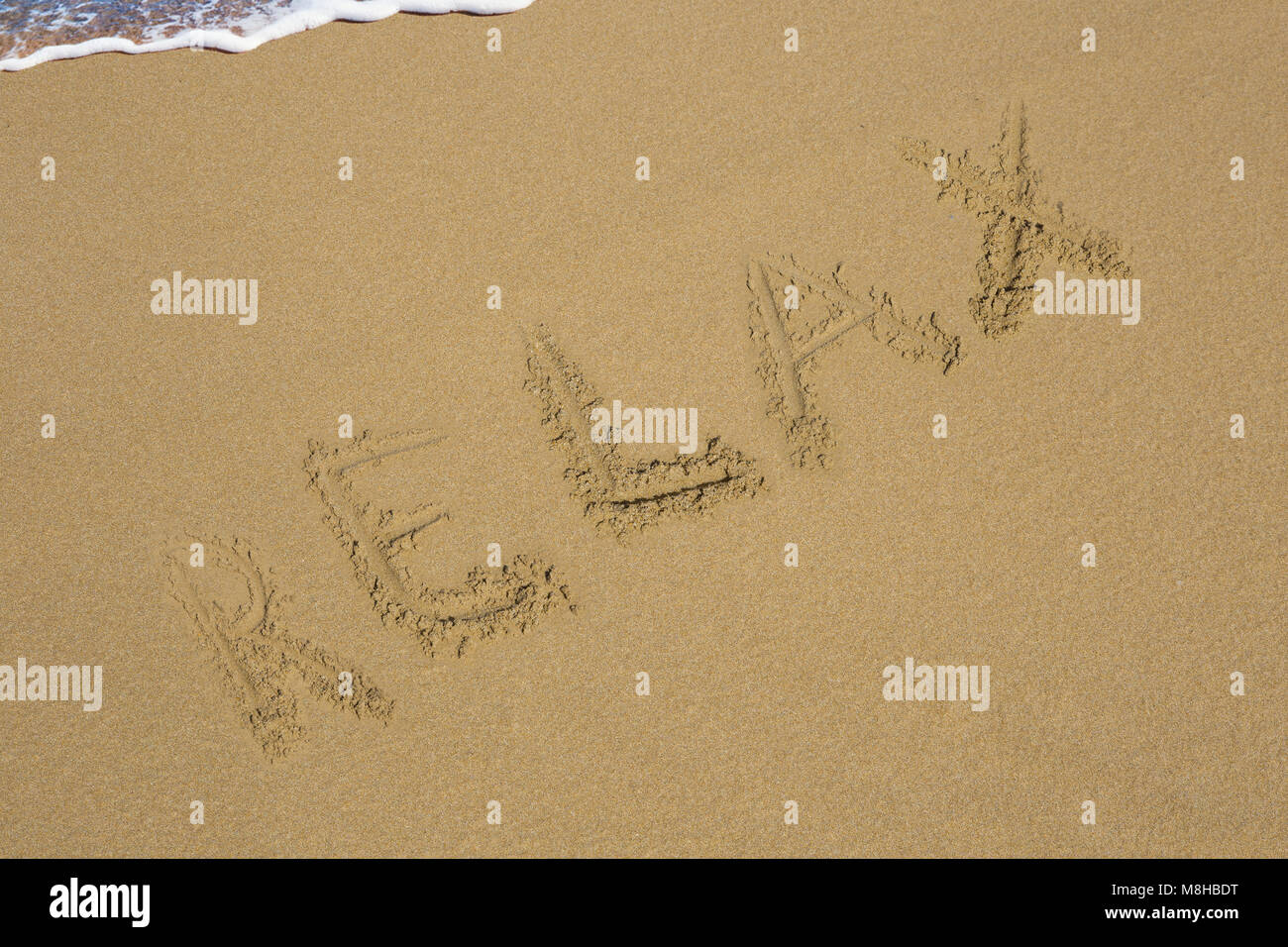 Word Relax written on the sand near the sea.Vacation concept Stock ...