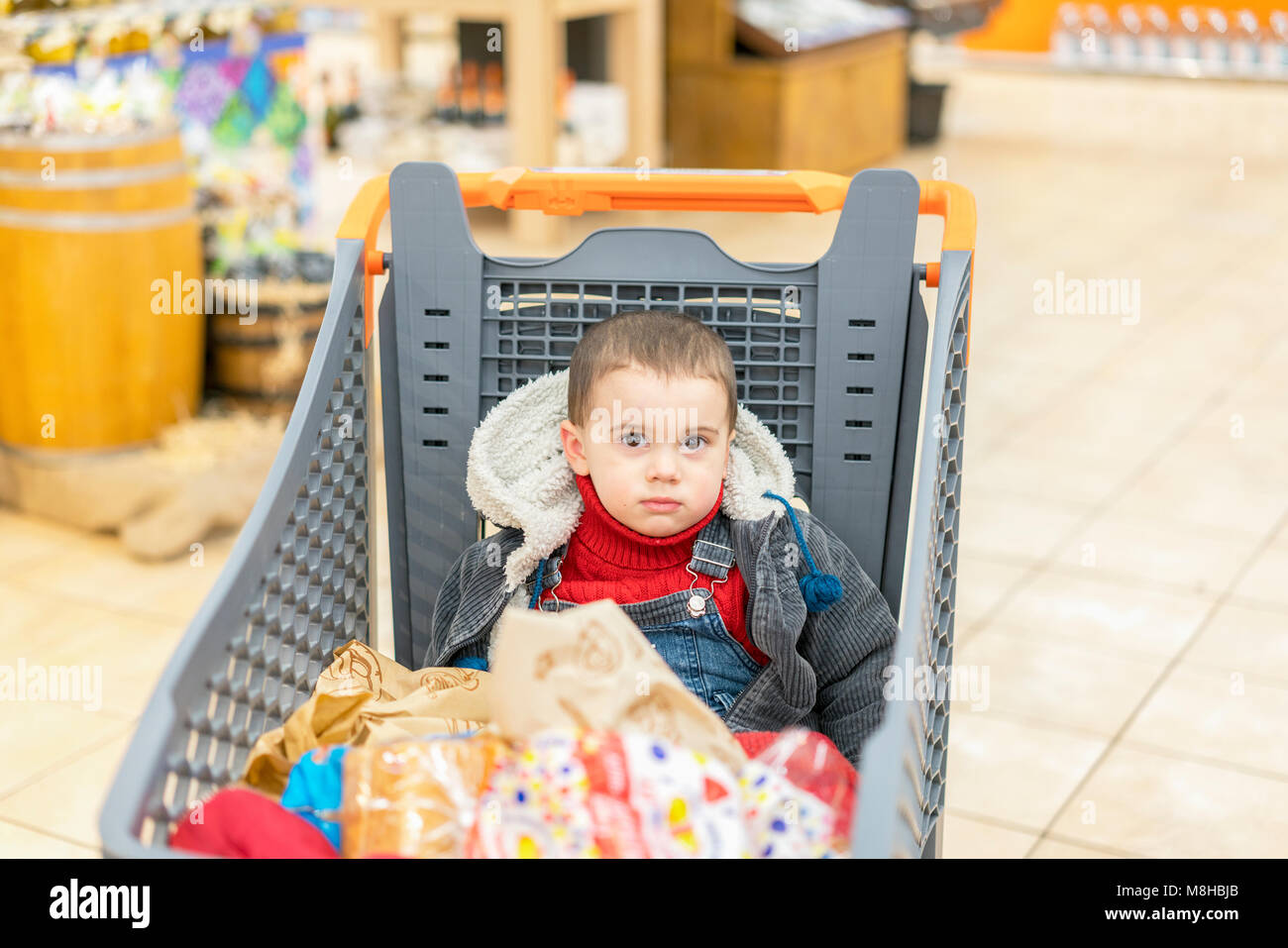 A trolley with products in which the child sits Stock Photo - Alamy