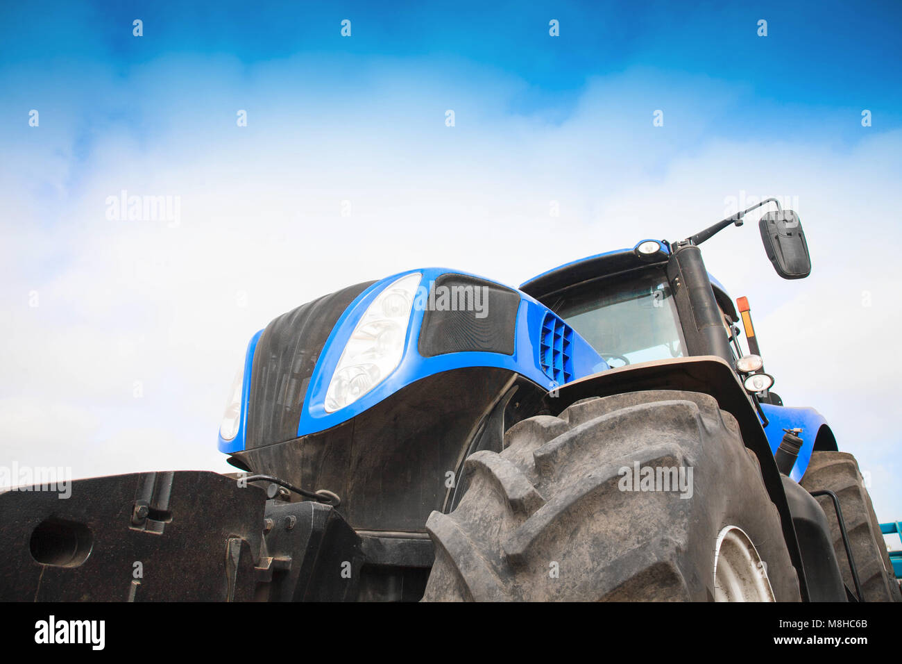 Blue tractor close-up against the sky Stock Photo - Alamy