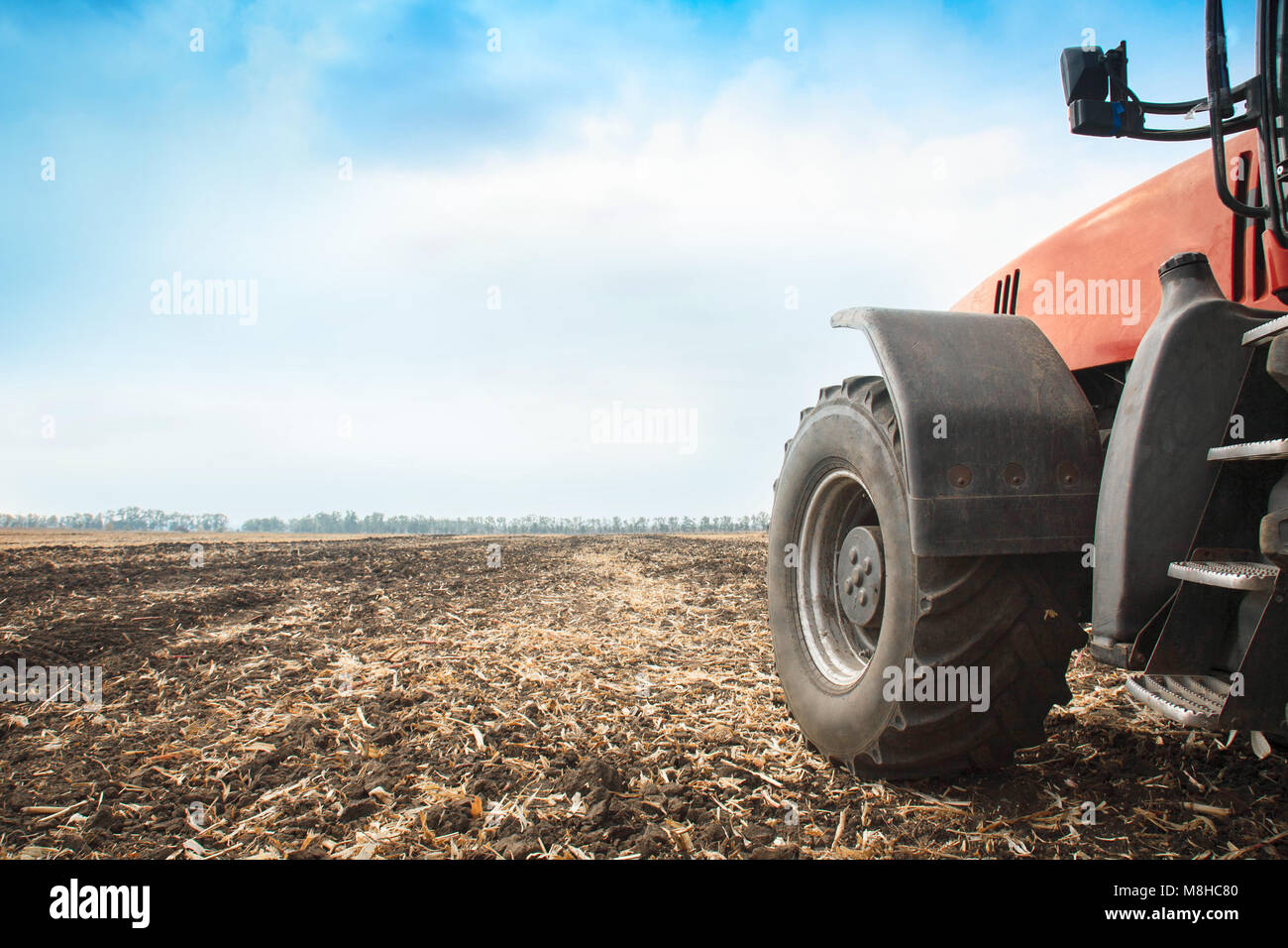 Modern red tractor in the field close-up on a bright sunny day Stock ...