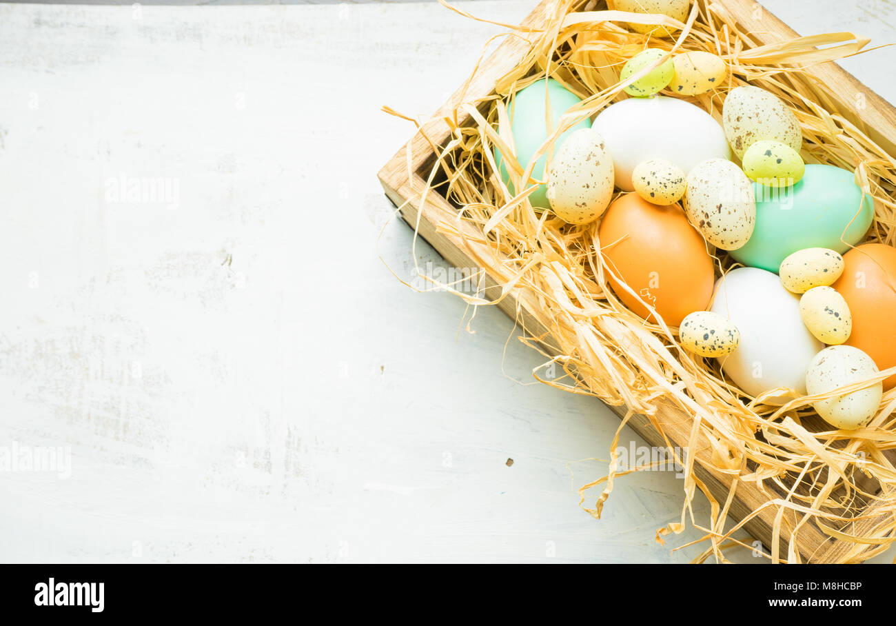 Easter festive frame with wooden box full of colored eggs on rustic ...