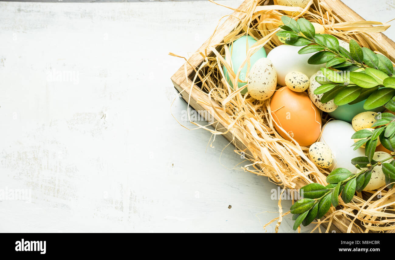 Easter festive frame with wooden box full of colored eggs on rustic ...